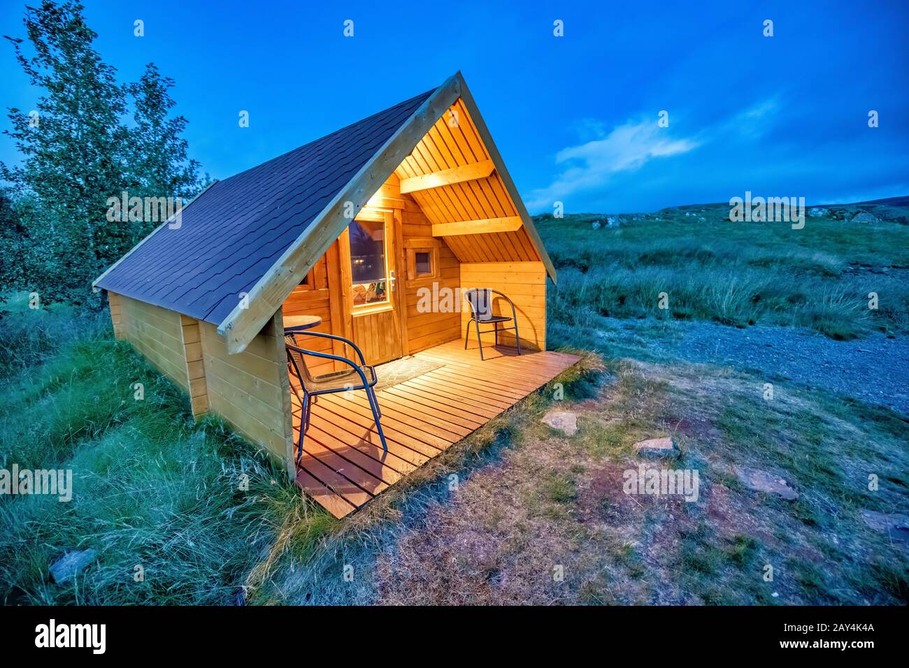 Beautiful chalet isolated in the mountains at sunset. Wooden front with ...