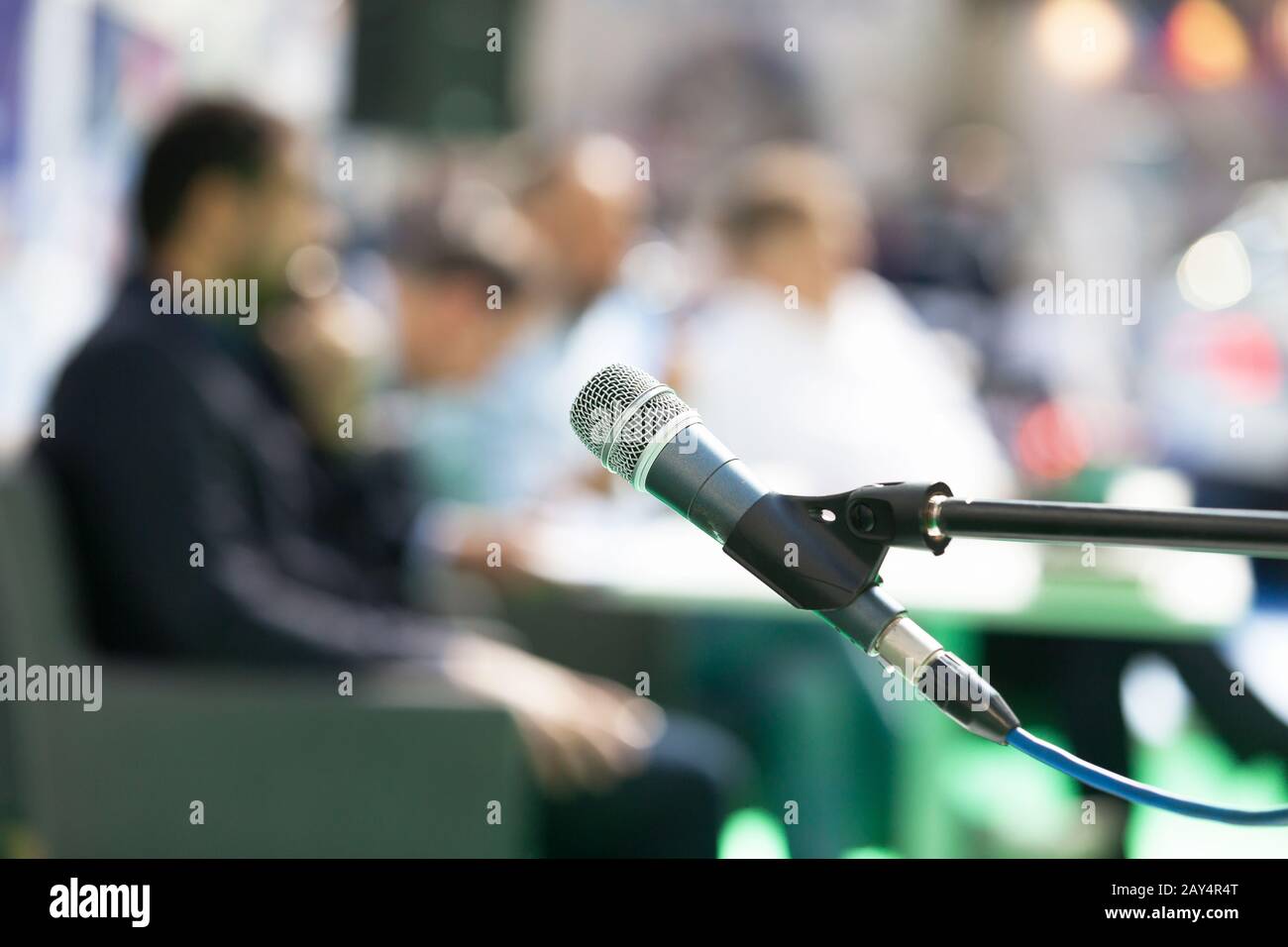 Microphone in focus against blurred people Stock Photo - Alamy