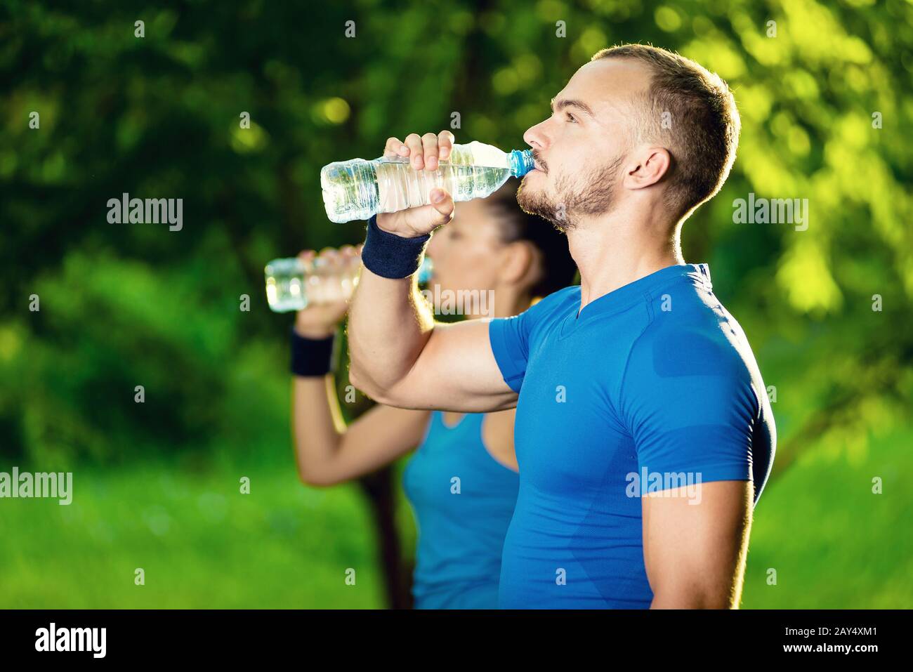 Man and woman drinking water from bottle after fitness sport exercise ...