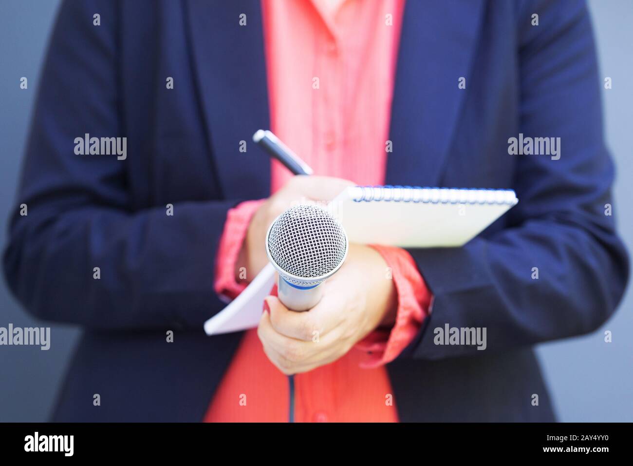 Female journalist at press conference, writing notes, holding ...