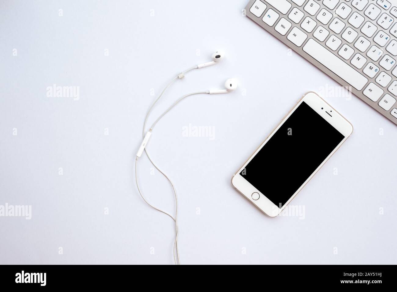 White office desk with a smartphone, earphones - Top view Stock Photo ...
