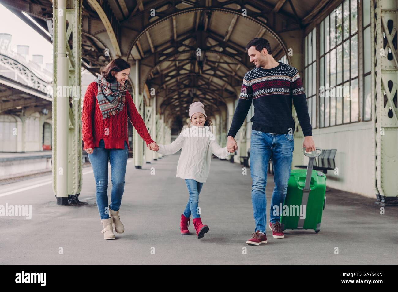 Three family members on railway station. Happy mother, daughter and ...