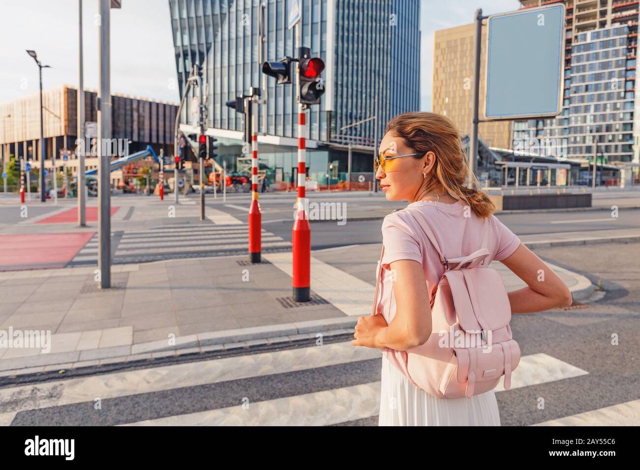 The girl is going to cross the road on a prohibiting red light. Road ...