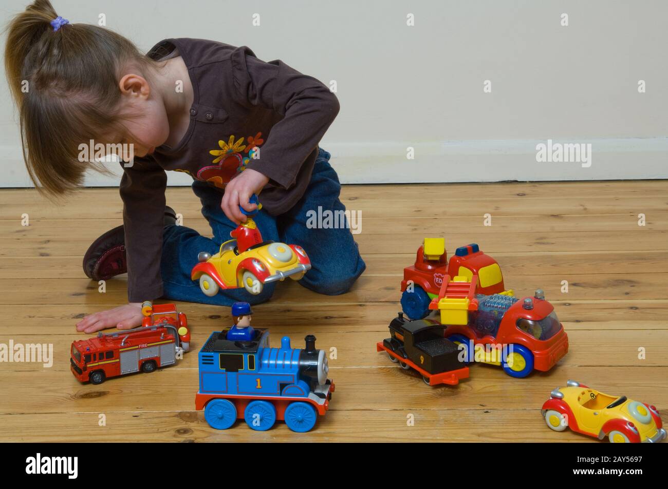 young girl playing with toy cars Stock Photo - Alamy