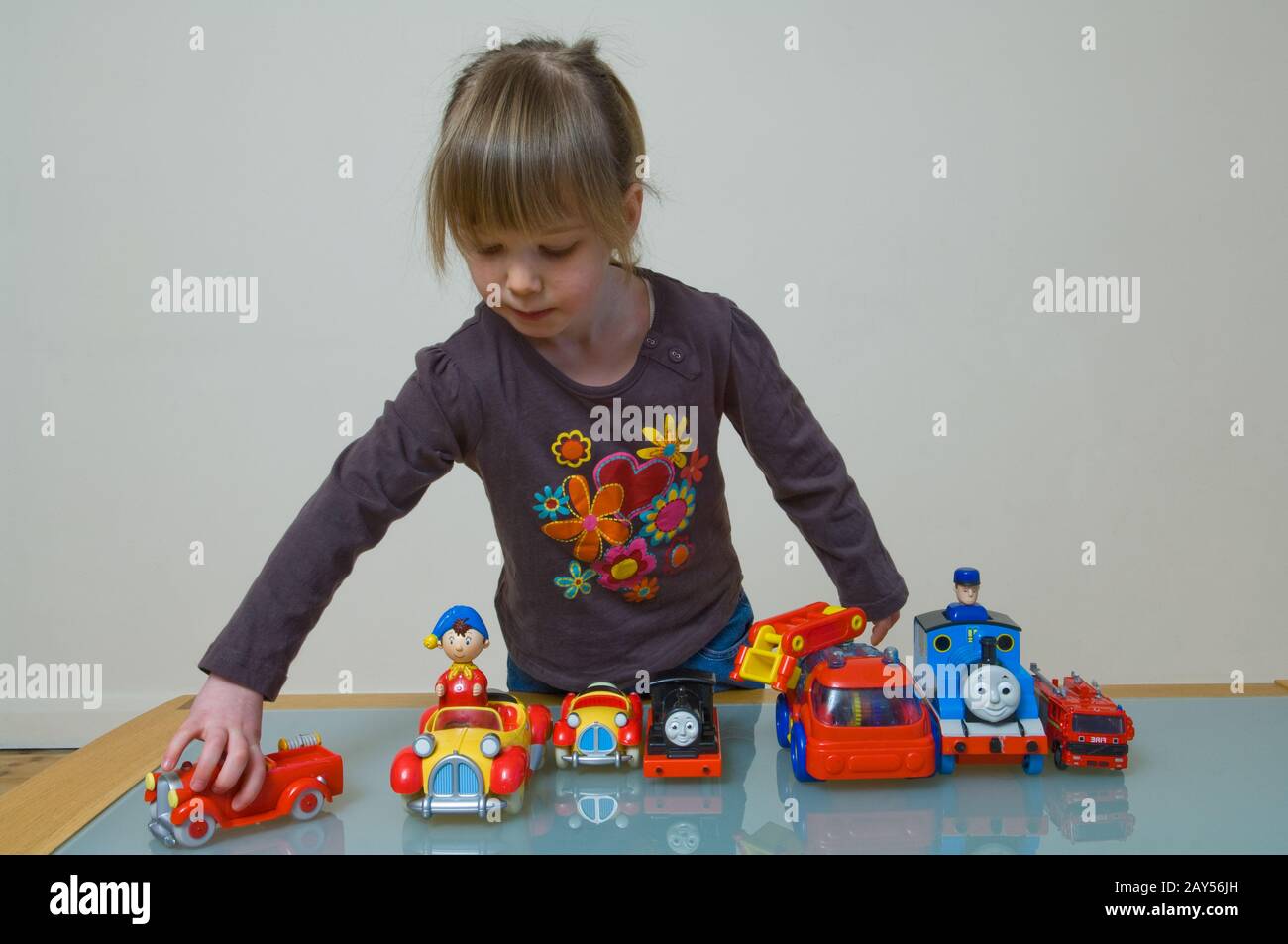 young girl playing with toy cars Stock Photo - Alamy