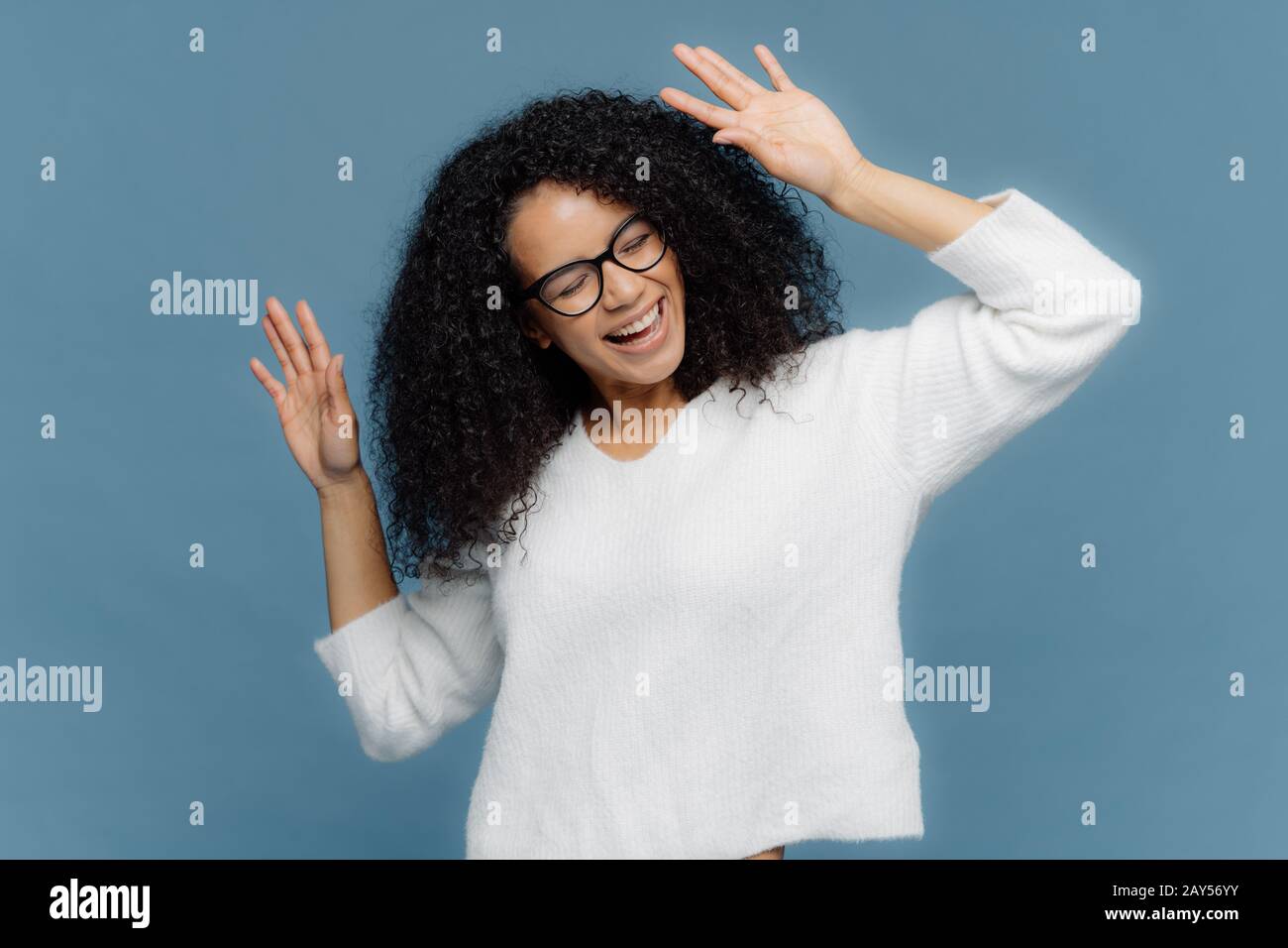 People and joy concept. Optimistic delighted Afro American woman raises ...