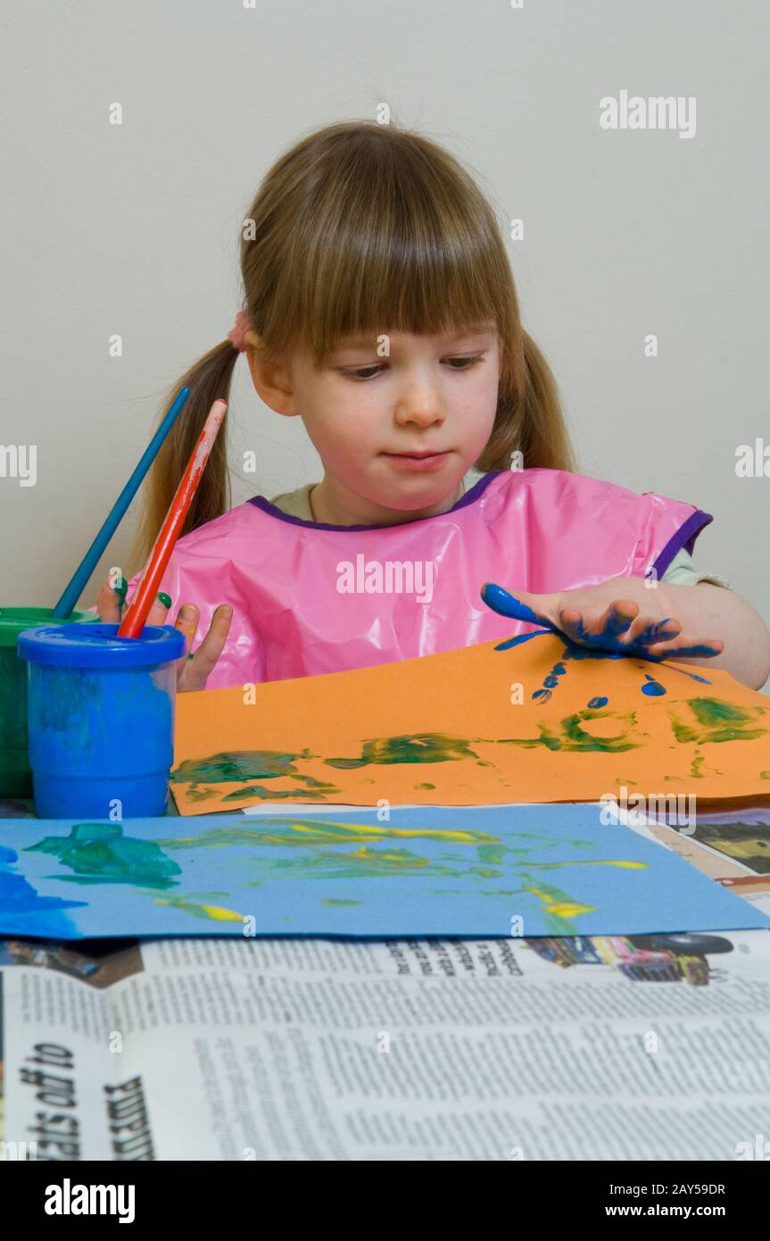 young girl doing hand prints with paint Stock Photo - Alamy