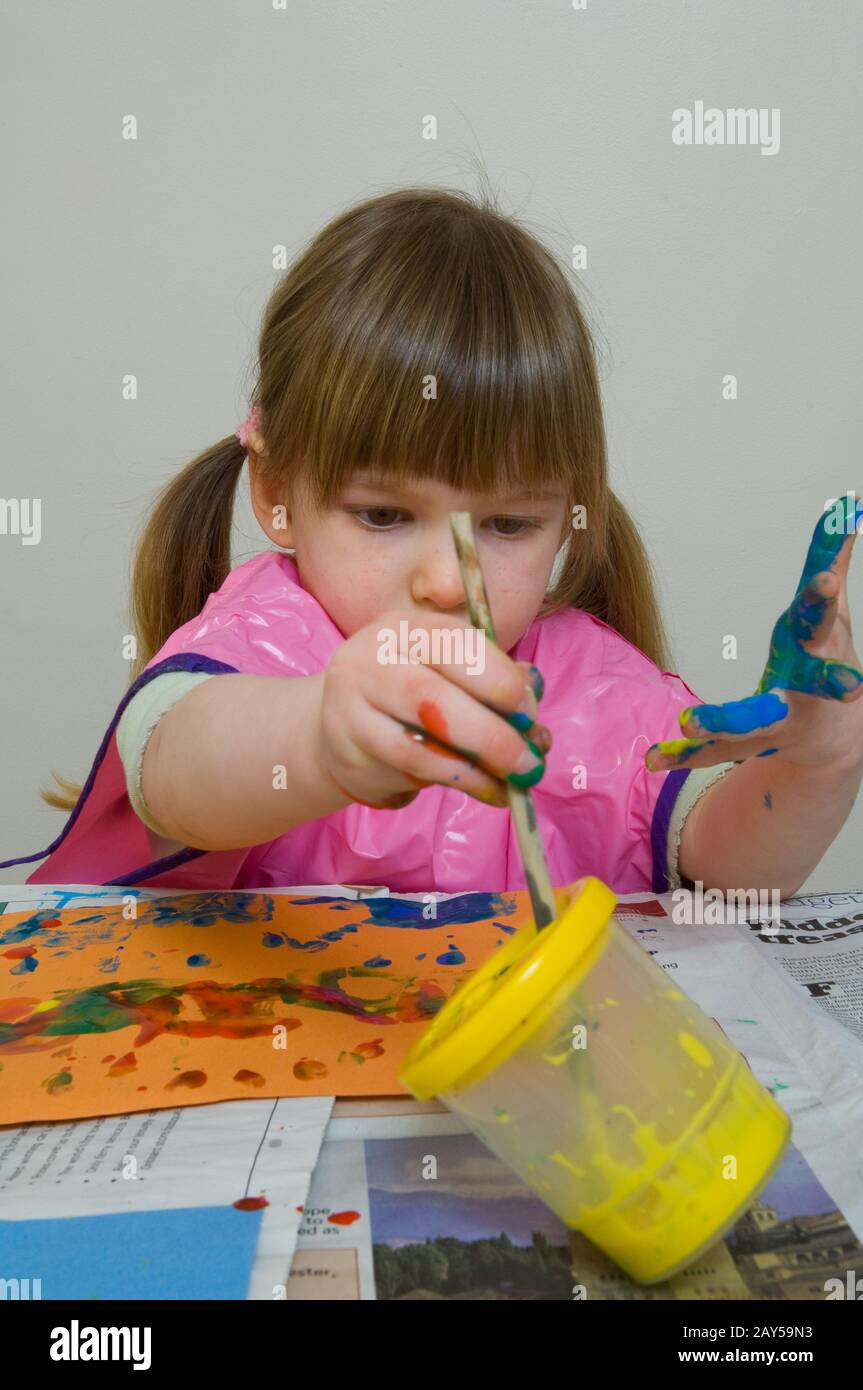 young girl doing hand prints with paint Stock Photo - Alamy