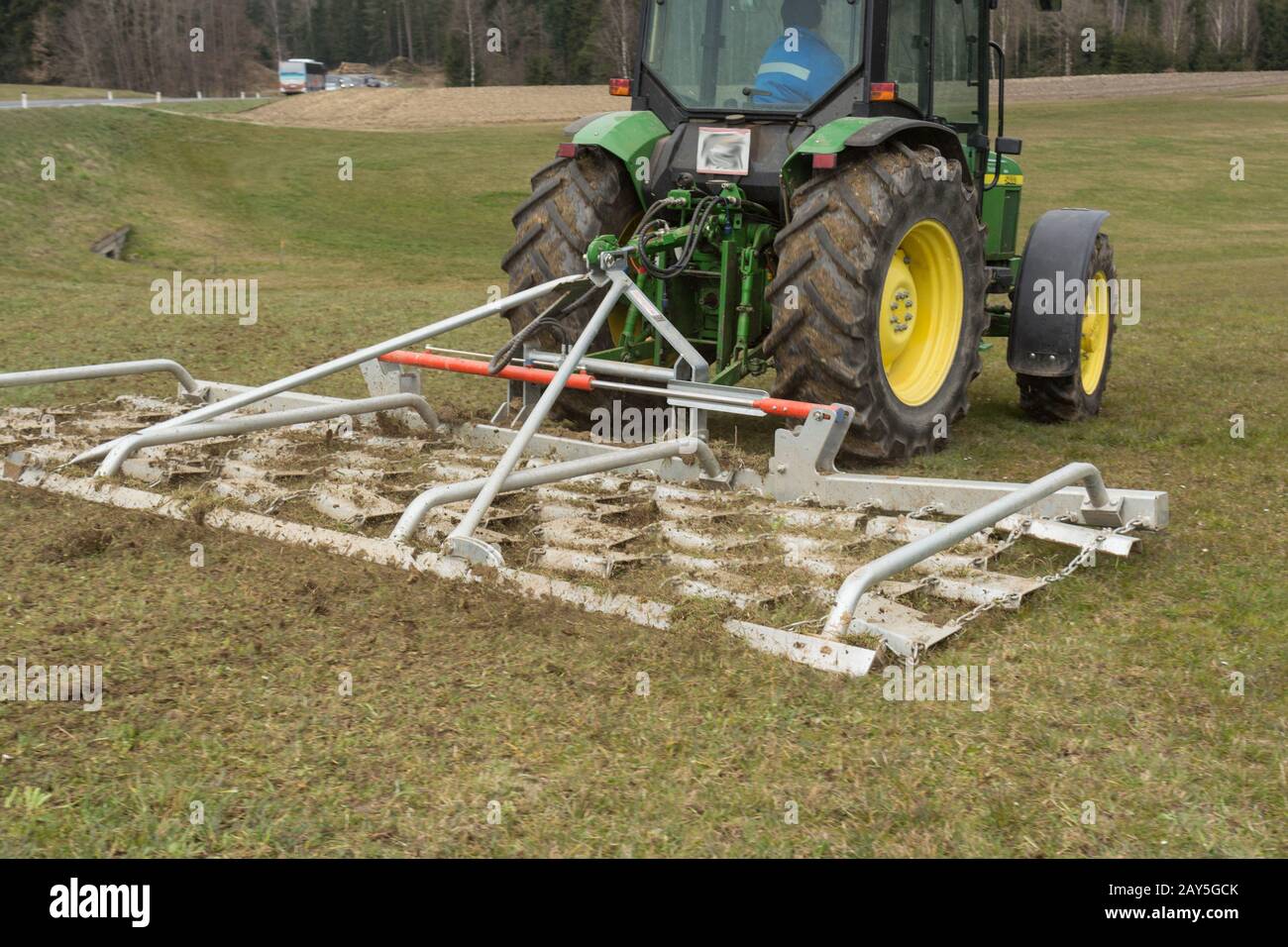Farmer with tractor and meadow harrow on the field - landscape ...