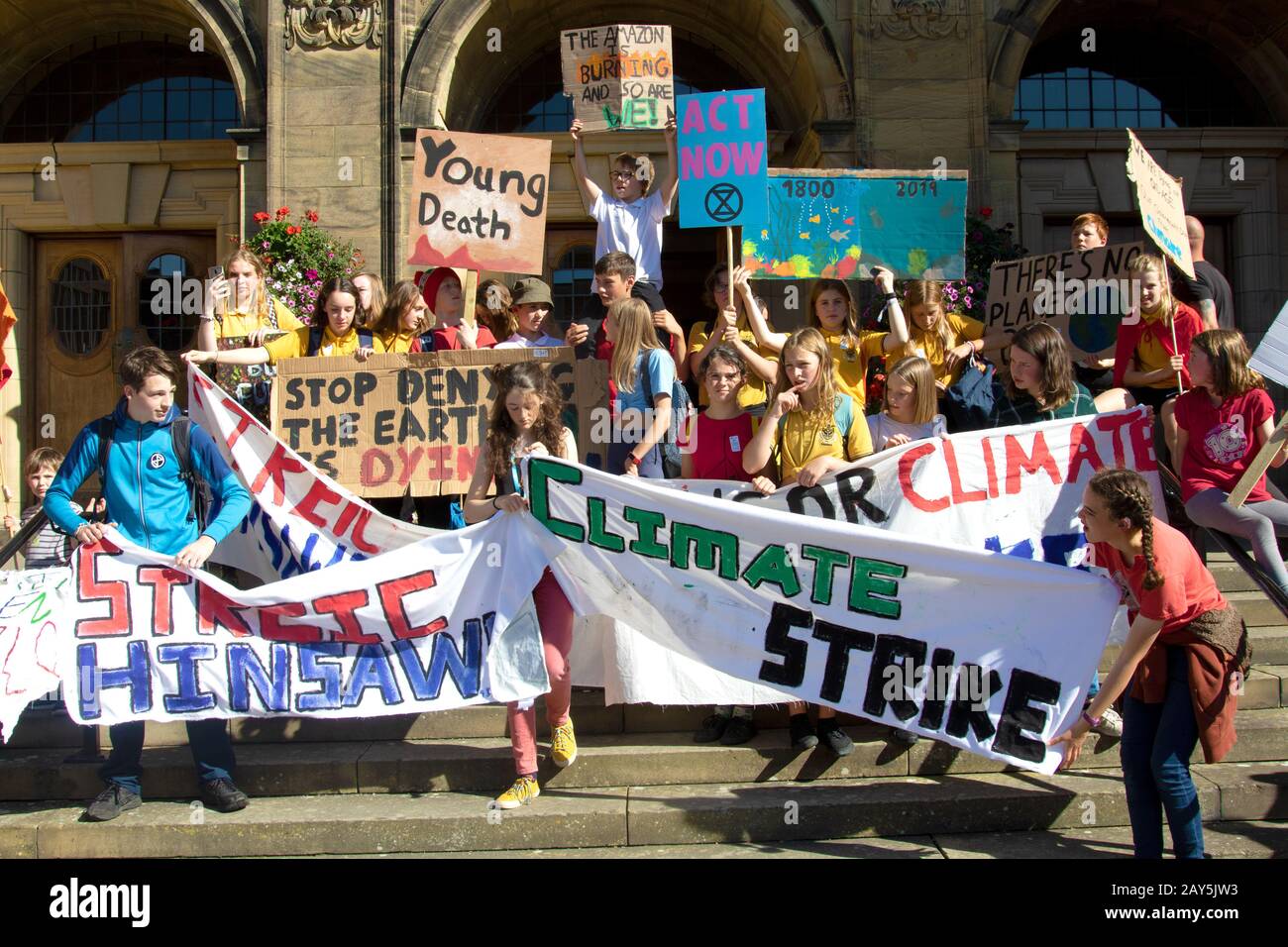 Young People pose of the steps of Bangor University with banners in ...