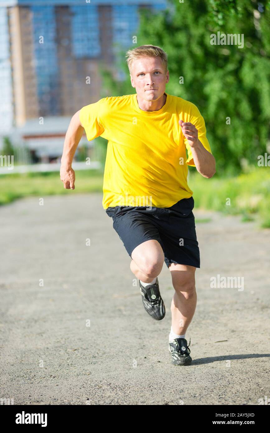 Sporty man jogging in city street park. Outdoor fitness Stock Photo - Alamy