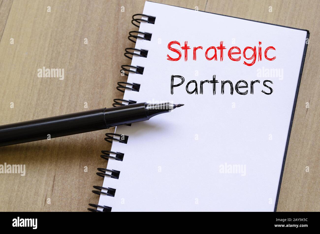 Strategic partners write on notebook Stock Photo - Alamy