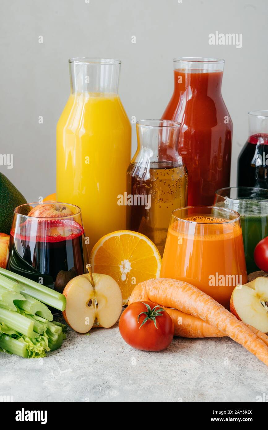 Vertical shot of fresh fruit and vegetable juice in glass bottles ...