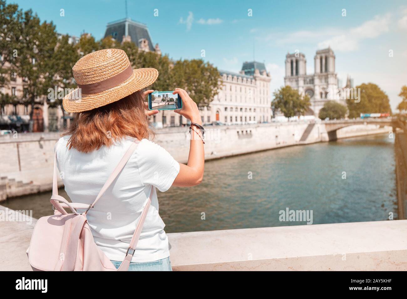 Happy traveler girl blogger takes photos of Notre Dame De Paris and the ...