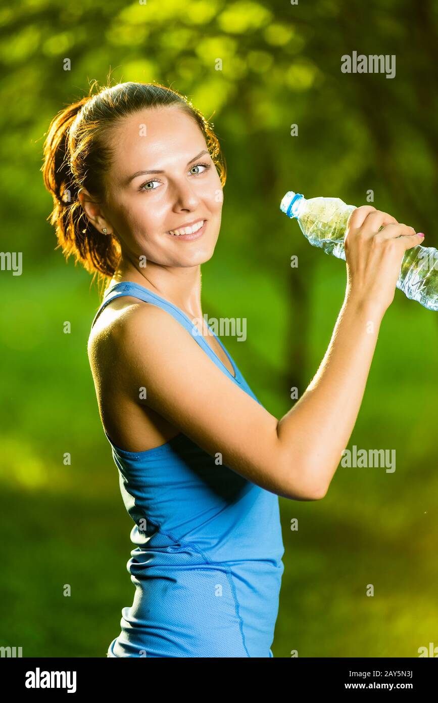 Young woman drinking water after fitness exercise Stock Photo - Alamy
