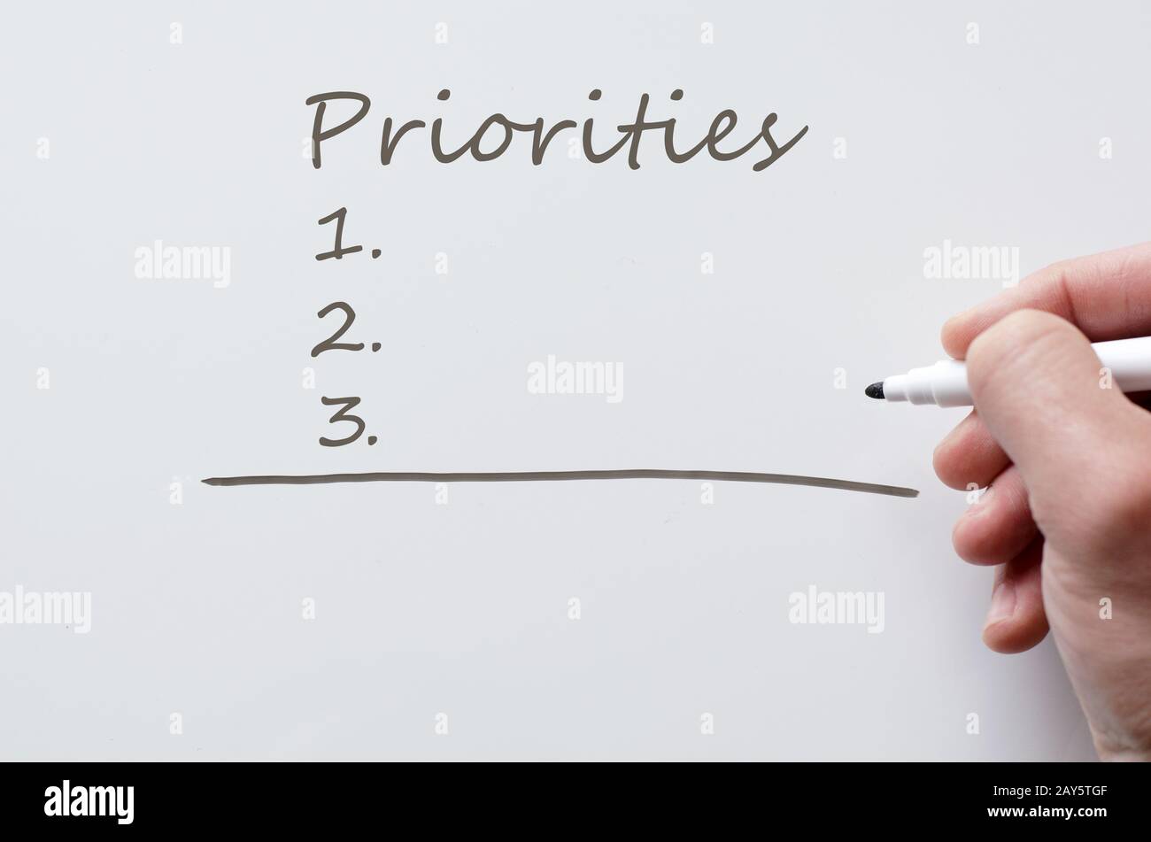 Priorities written on whiteboard Stock Photo - Alamy