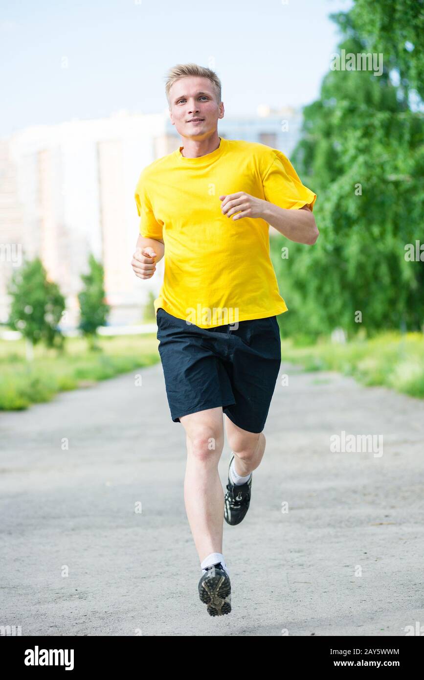 Sporty man jogging in city street park. Outdoor fitness Stock Photo - Alamy
