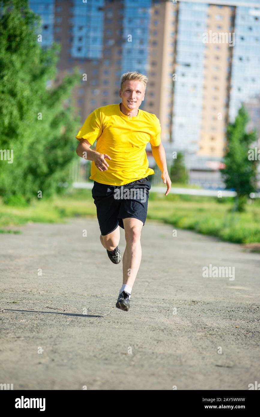 Sporty man jogging in city street park. Outdoor fitness Stock Photo - Alamy