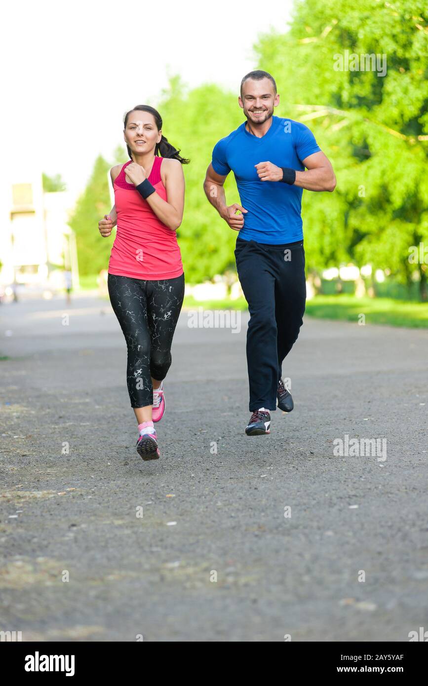Runners training outdoors working out. City running couple jogging ...