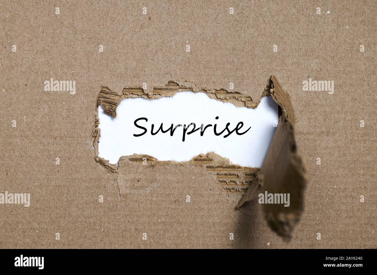 The word surprise appearing behind torn paper Stock Photo - Alamy