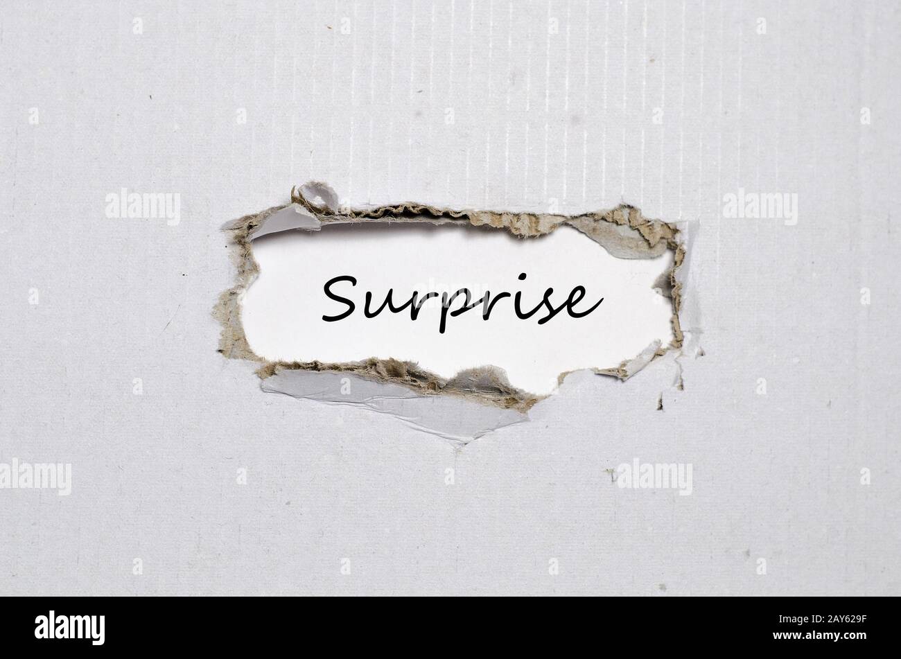 The word surprise appearing behind torn paper Stock Photo - Alamy