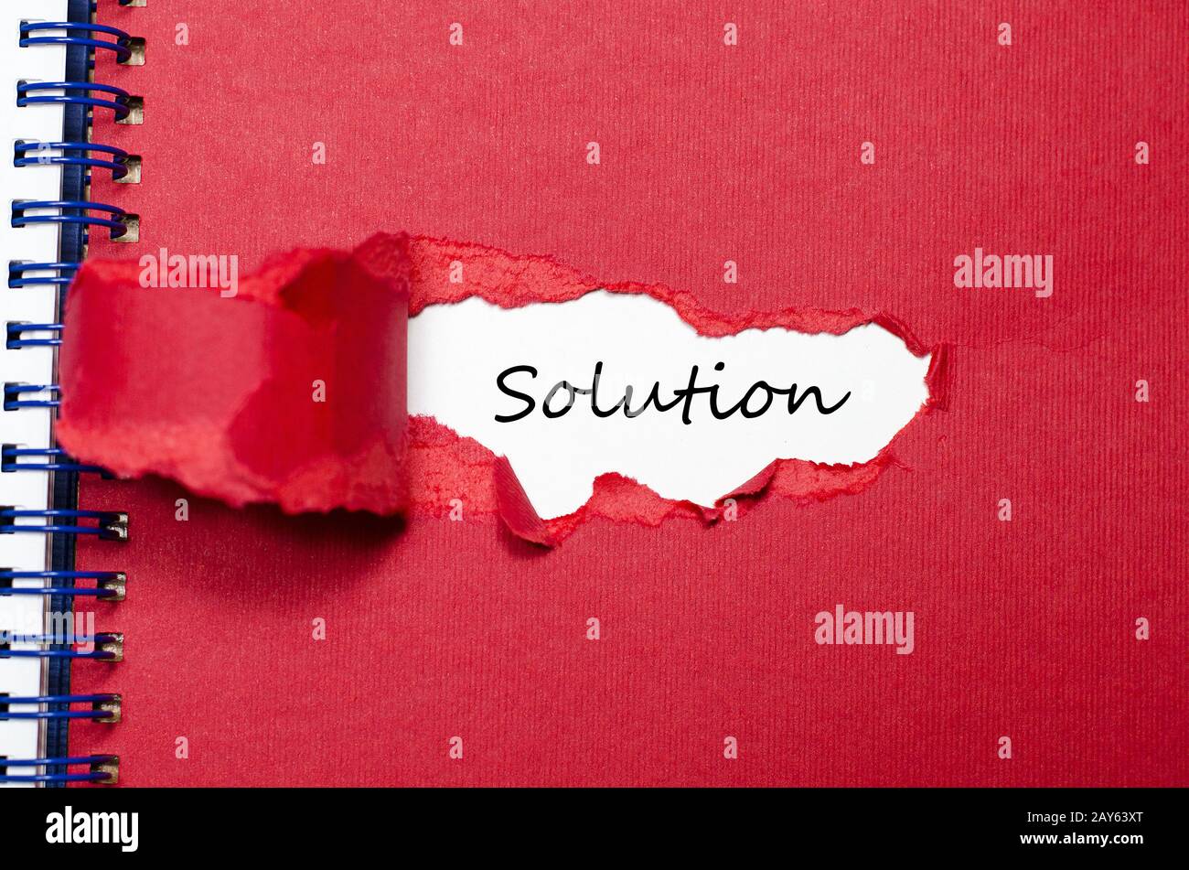 The word solution appearing behind torn paper Stock Photo - Alamy