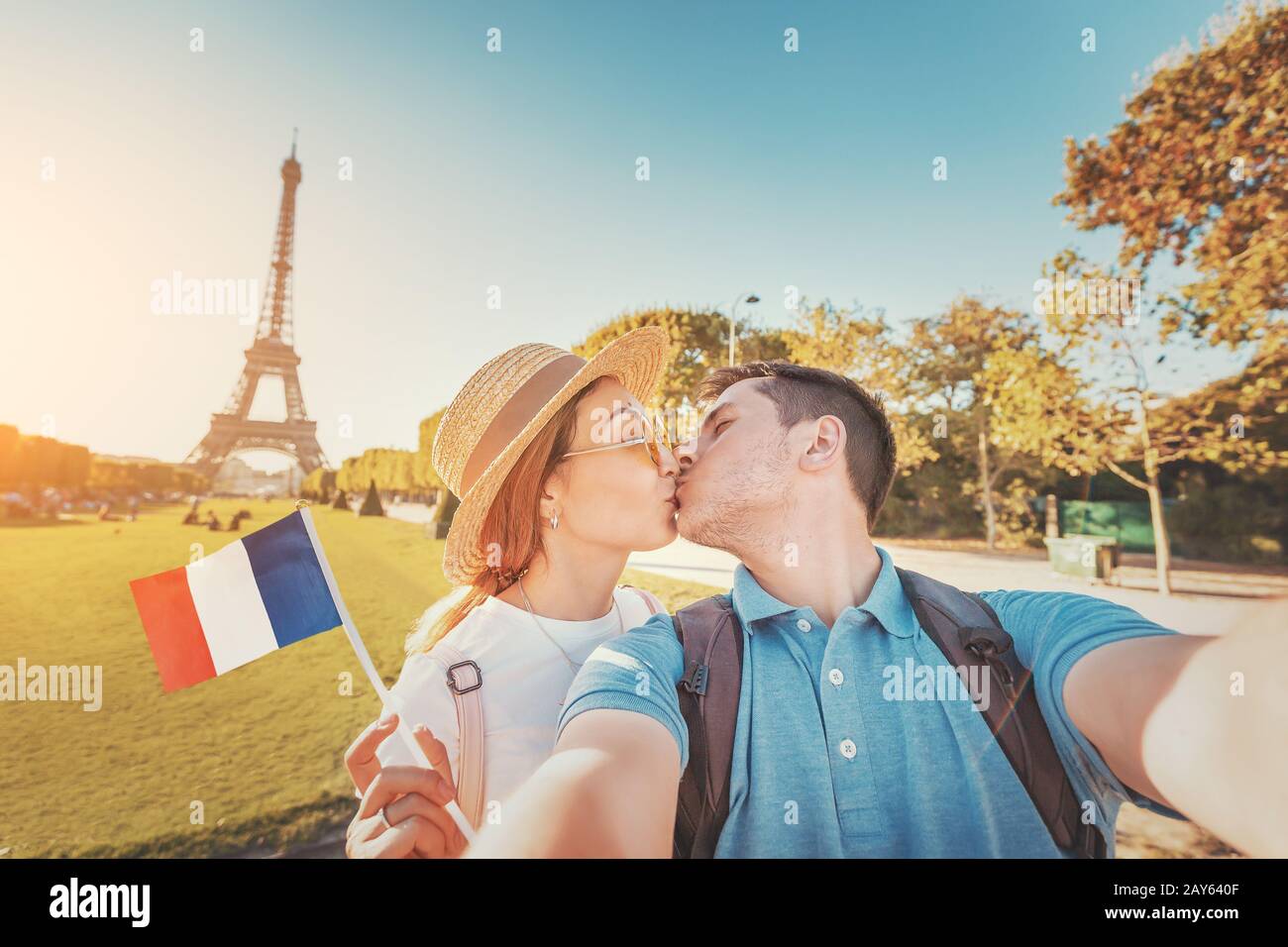 Mixed race couple in love hugging and taking selfie with french flag ...