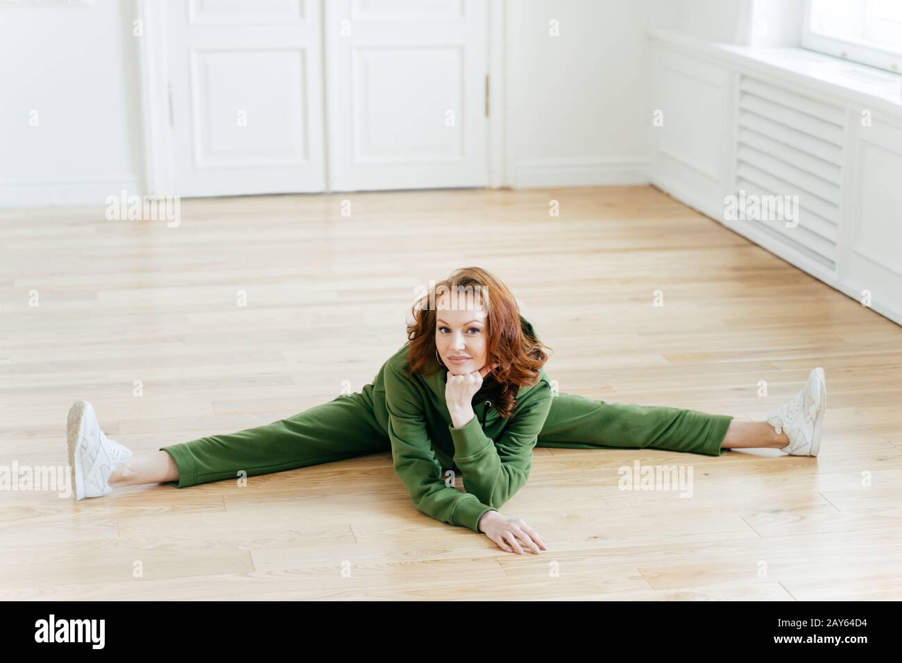 Flexibility, fitness and stretching concept. Attractive redhead female ...
