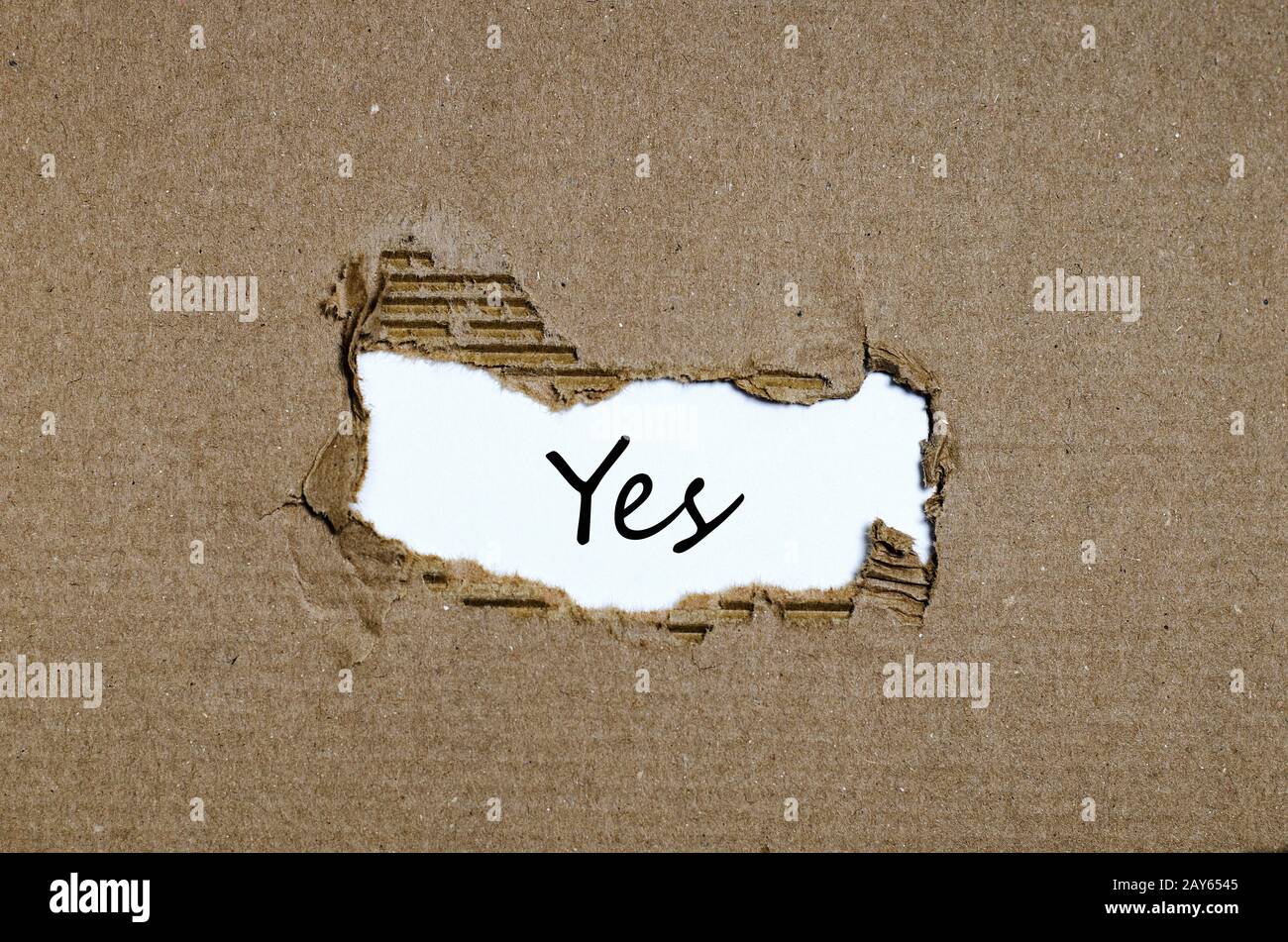 The word yes appearing behind torn paper Stock Photo - Alamy