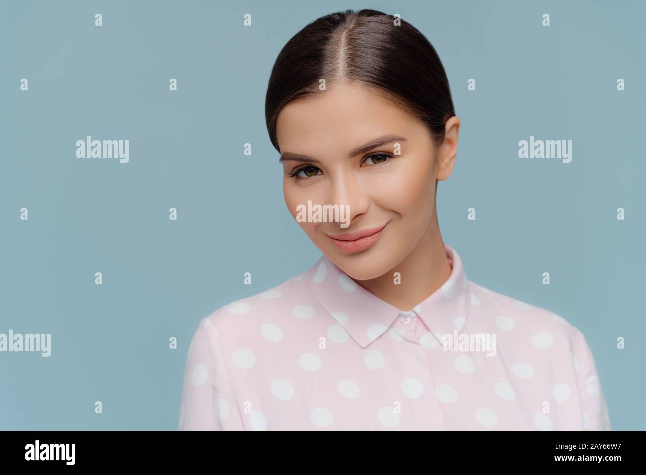 Headshot of pleasant looking dark haired female has pleased facial ...