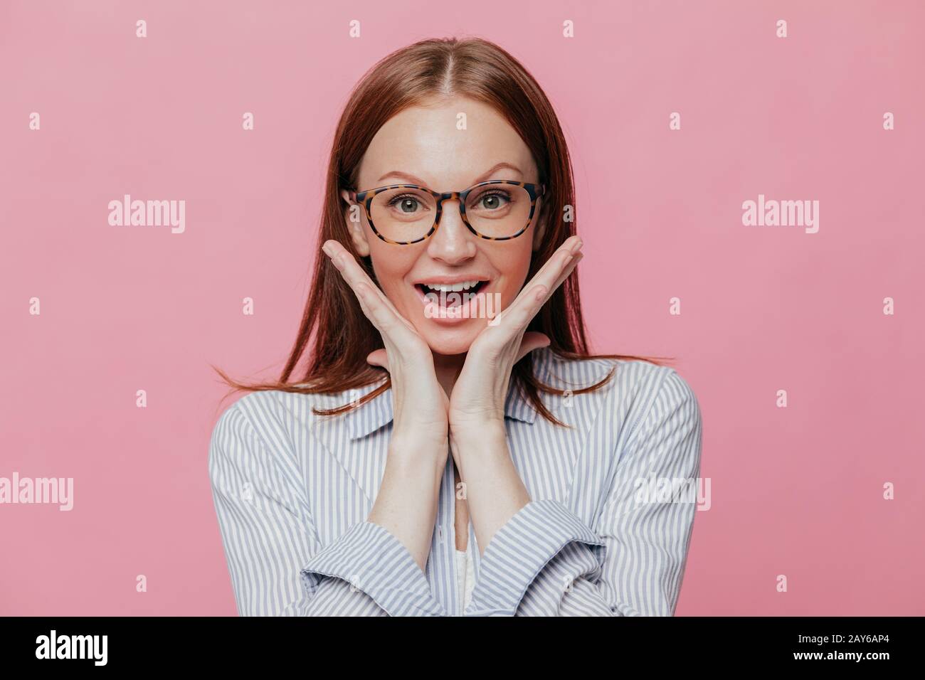 Happy Woman Keeps Hands Under Chin Feels Delighted And Satisfied