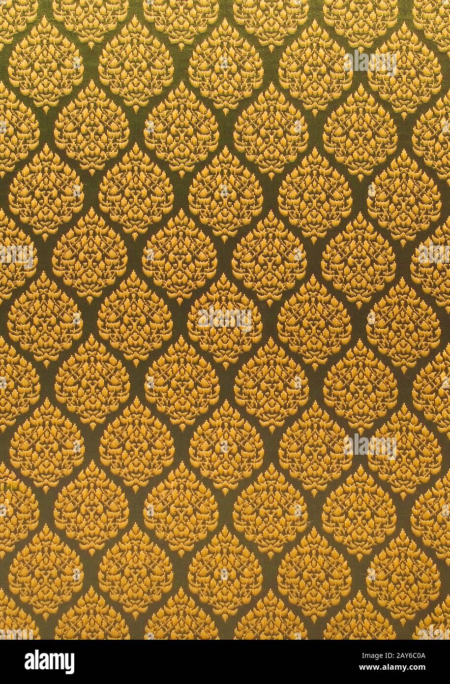 Elegant golden thread repeating pattern over a textile surface. Close ...