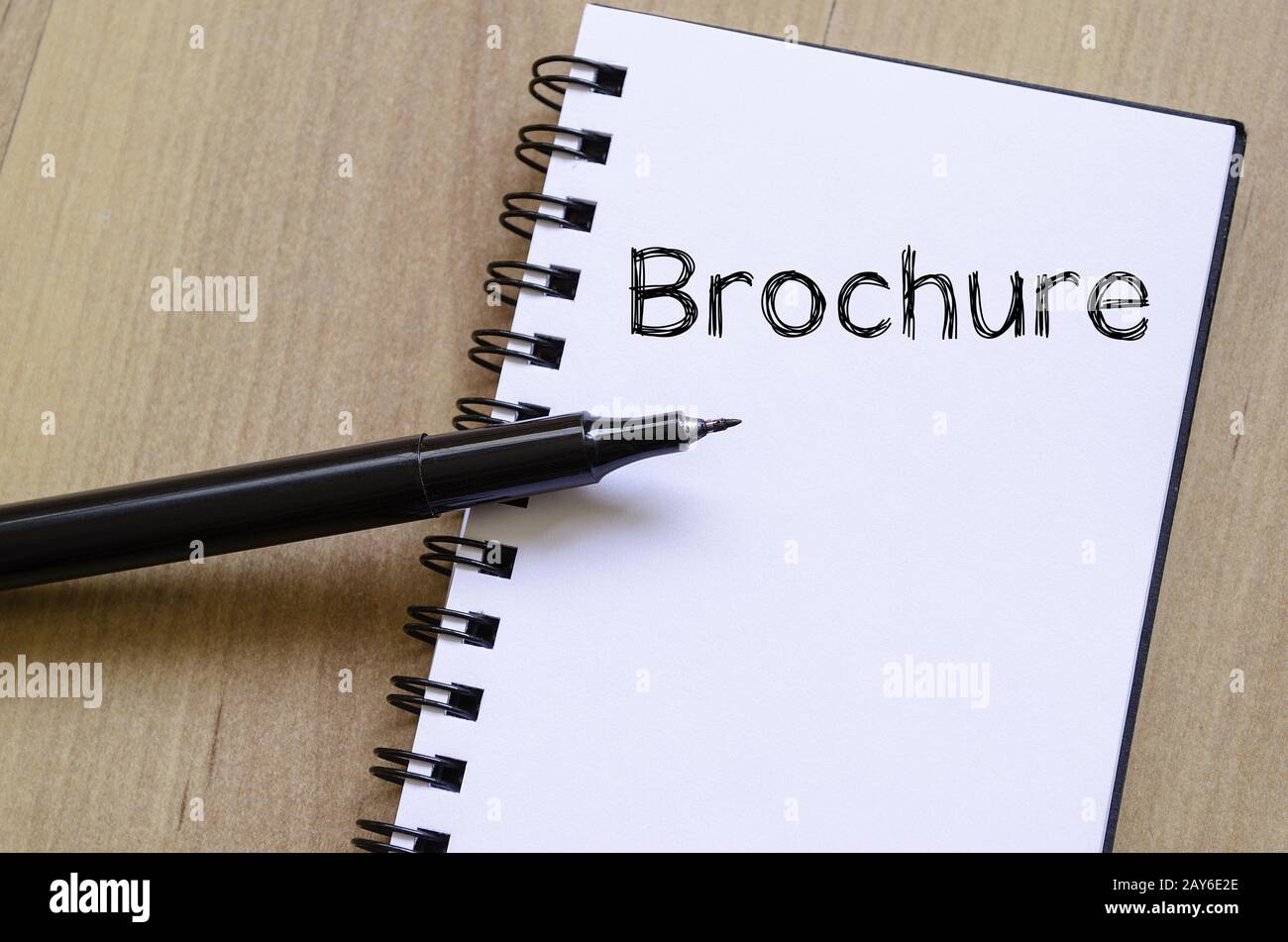 Brochure text concept on notebook Stock Photo - Alamy
