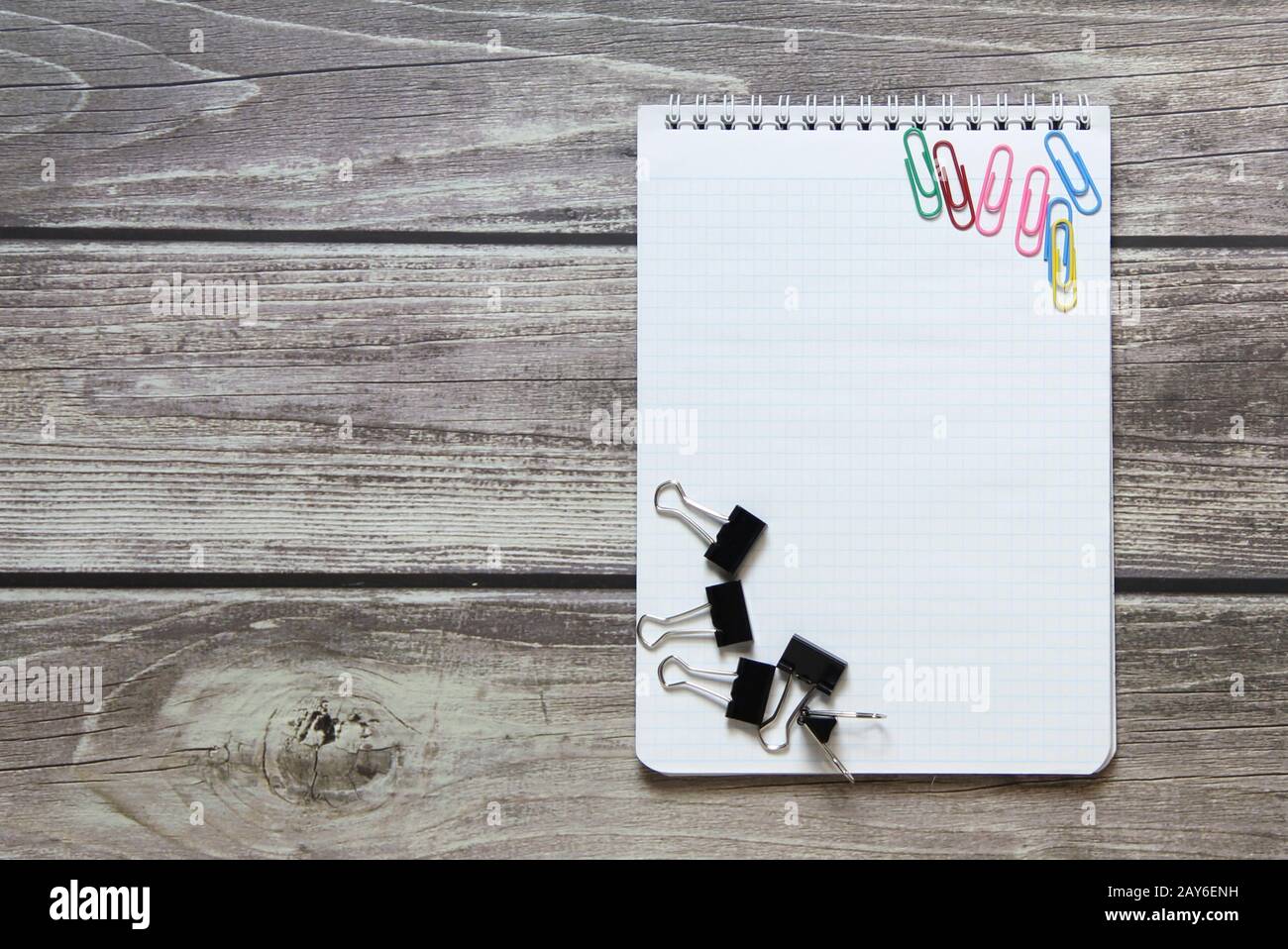 Notepad with a blank white sheet in a checker paper with a clip and ...