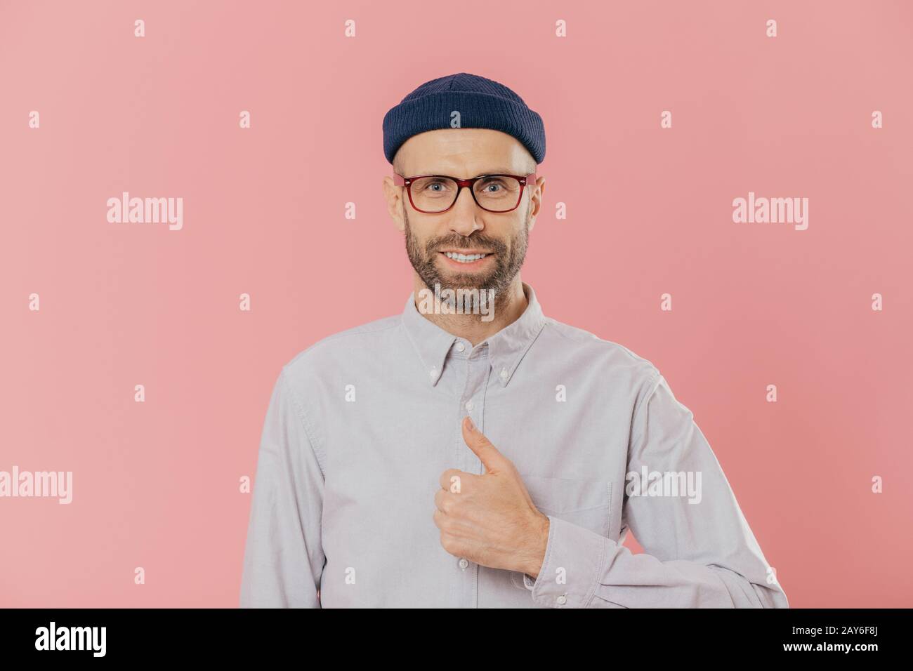 Satisfied attractive man has appealing look, raises thumb, agrees with ...