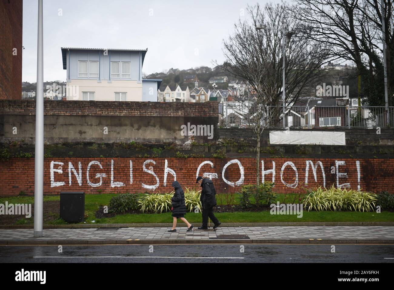 Anti English graffiti is written in white paint on a brick wall in the ...
