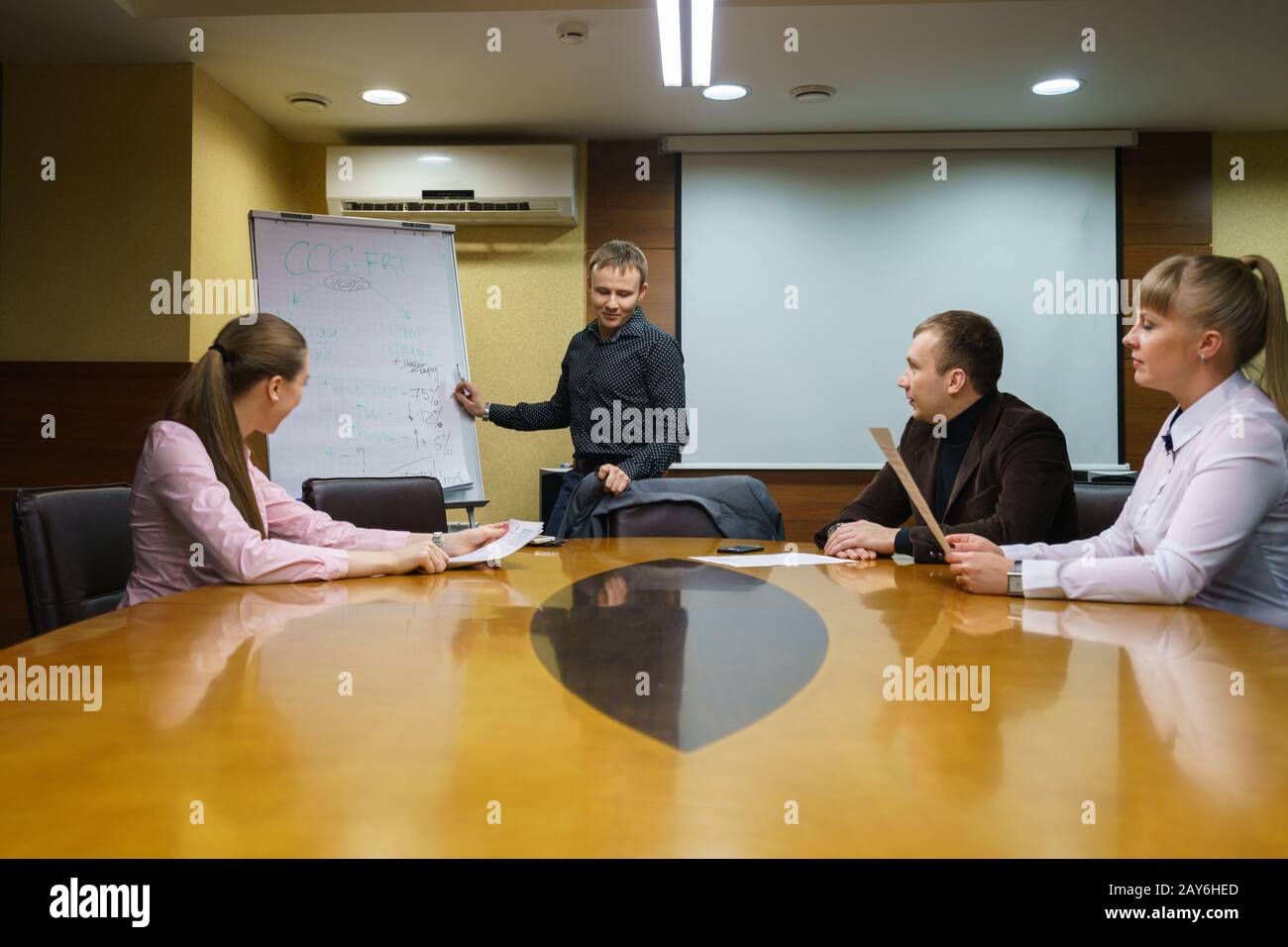 Young man leading conference for business people Stock Photo - Alamy