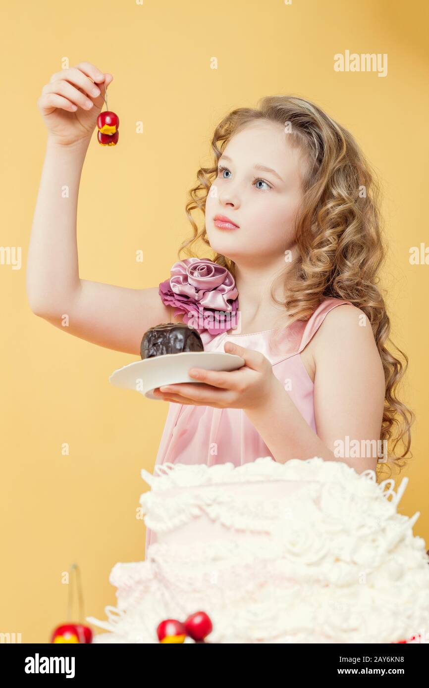 Adorable little girl posing with cake in studio Stock Photo - Alamy