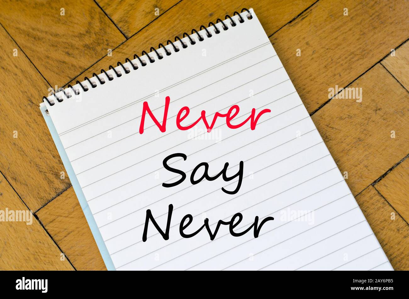 Human hand over wooden background and never say never text concept ...