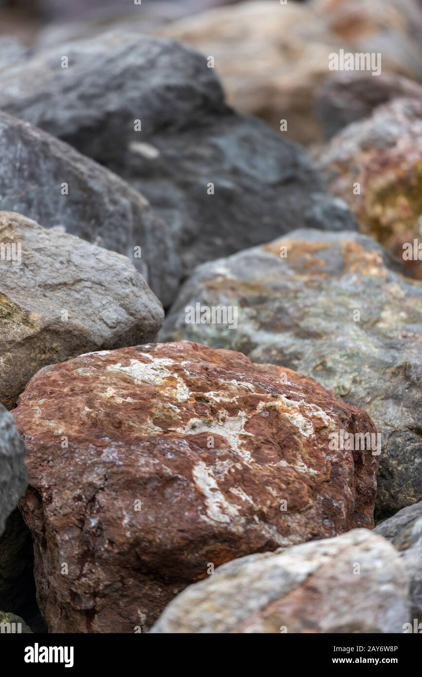 granite rocks with fissures in a different white colour on a beach as ...