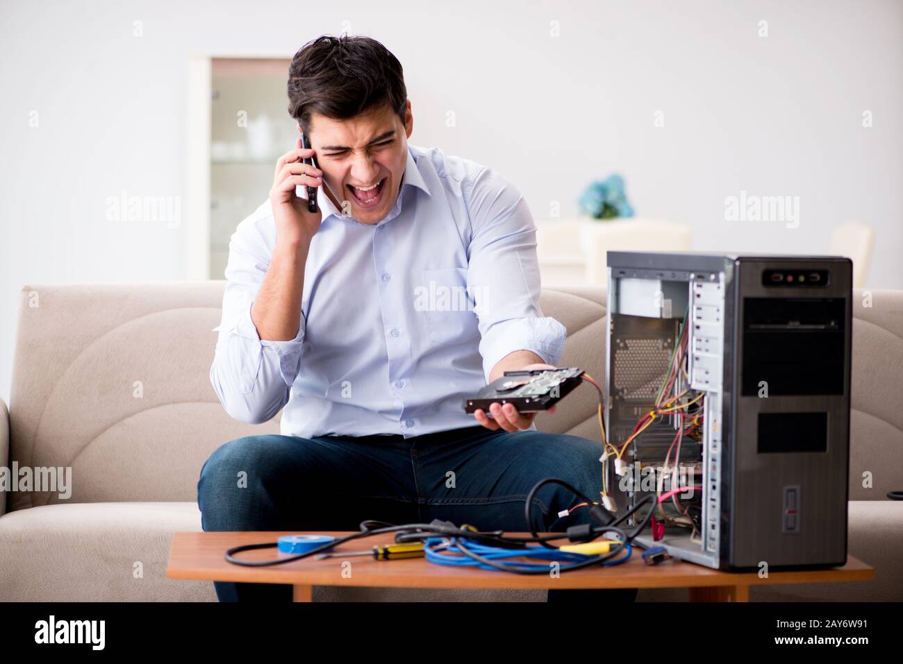 Angry customer trying to repair computer with phone support Stock Photo ...