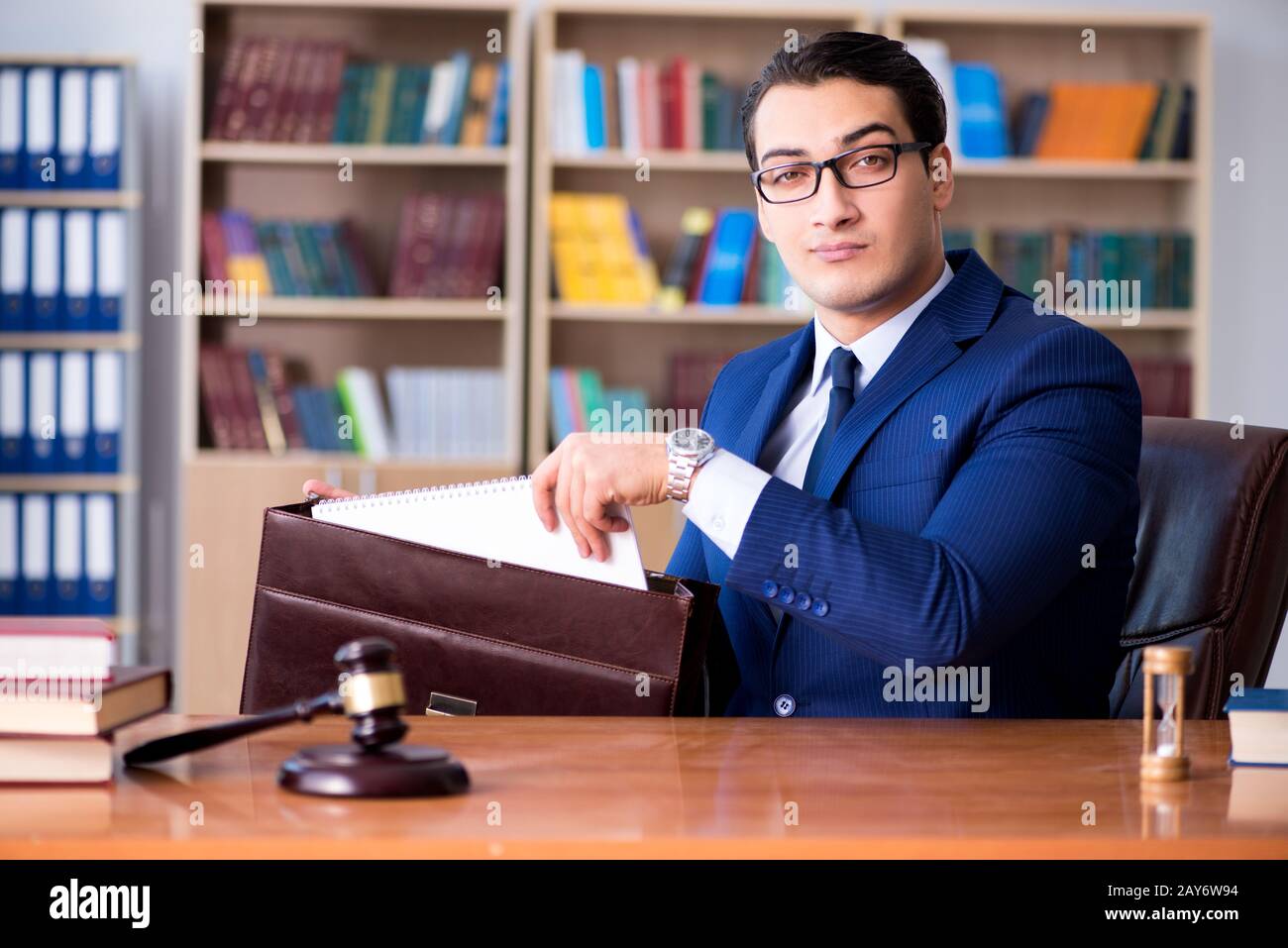 Handsome judge with gavel sitting in courtroom Stock Photo - Alamy