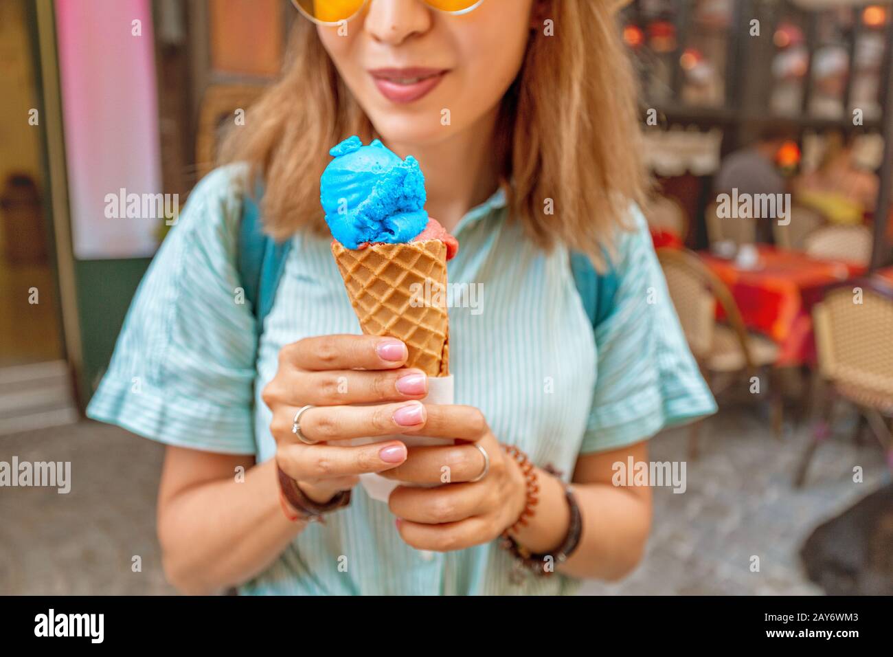 Happy woman eating ice cream at the city street. Food and joy concept ...