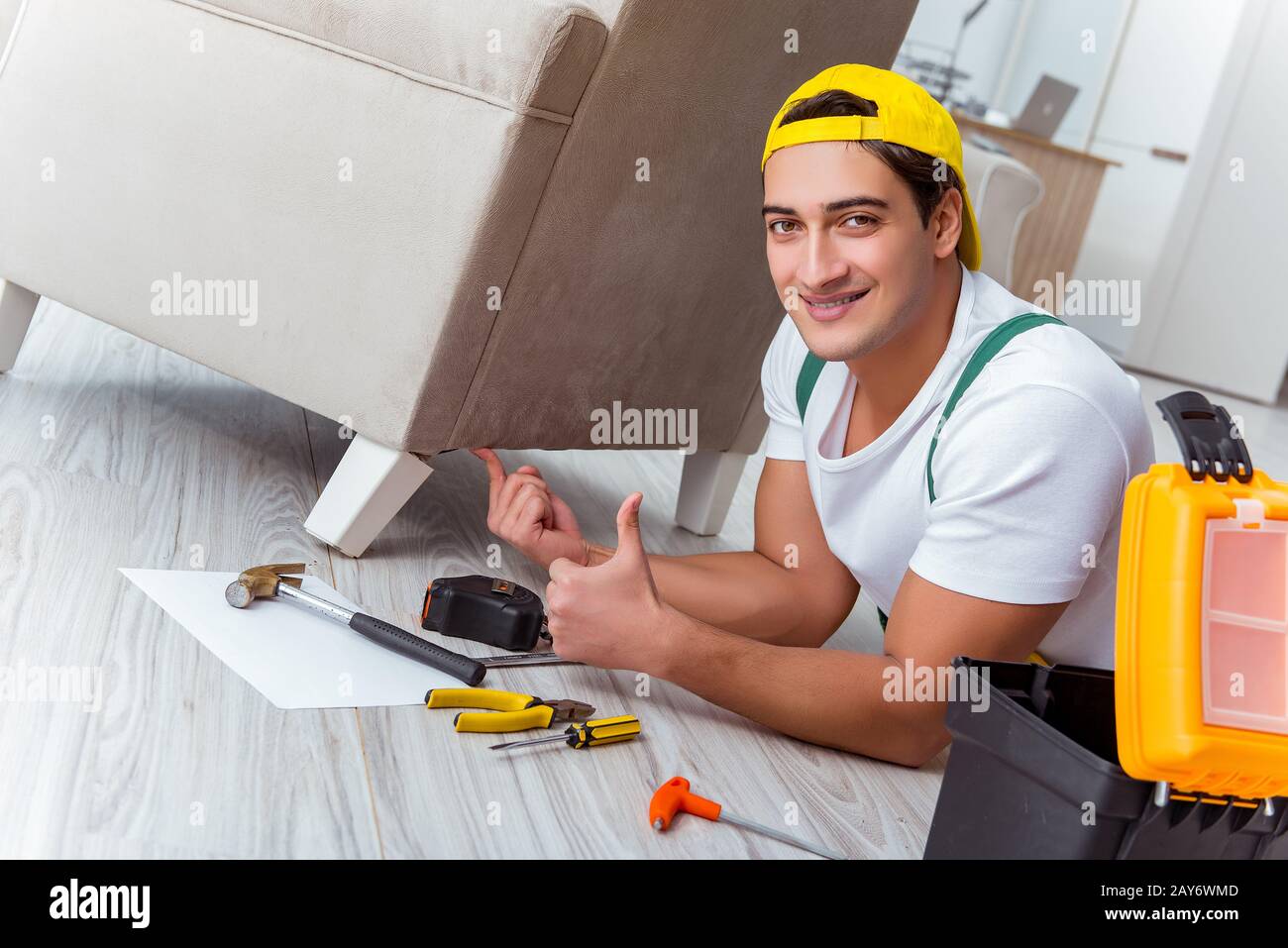 Worker repairing furniture at home Stock Photo - Alamy