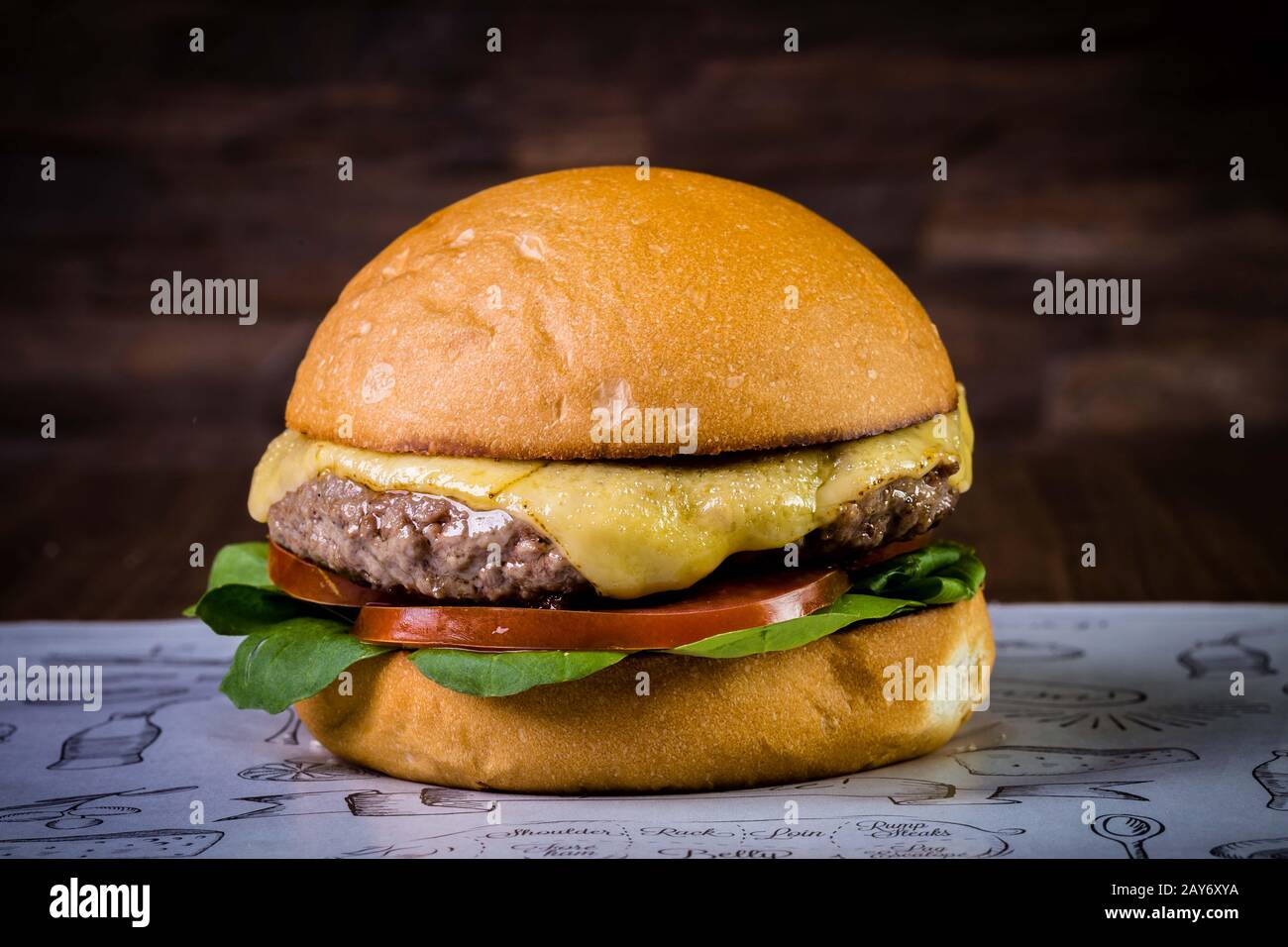 Craft beef burger with cheese and rocket leafs on wood table and rustic ...