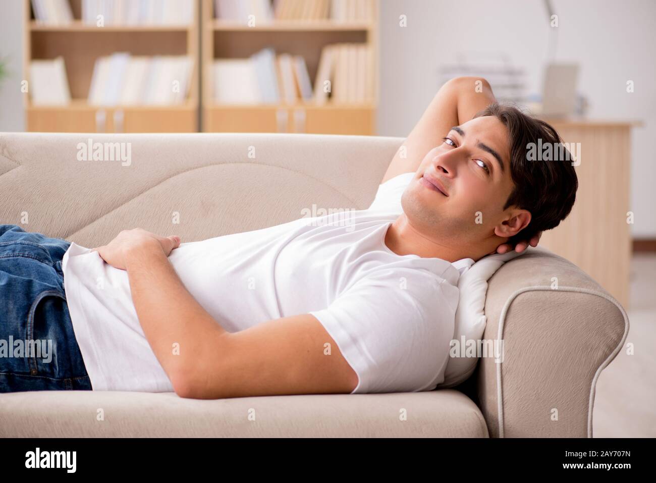 Young man sleeping in sofa couch Stock Photo - Alamy
