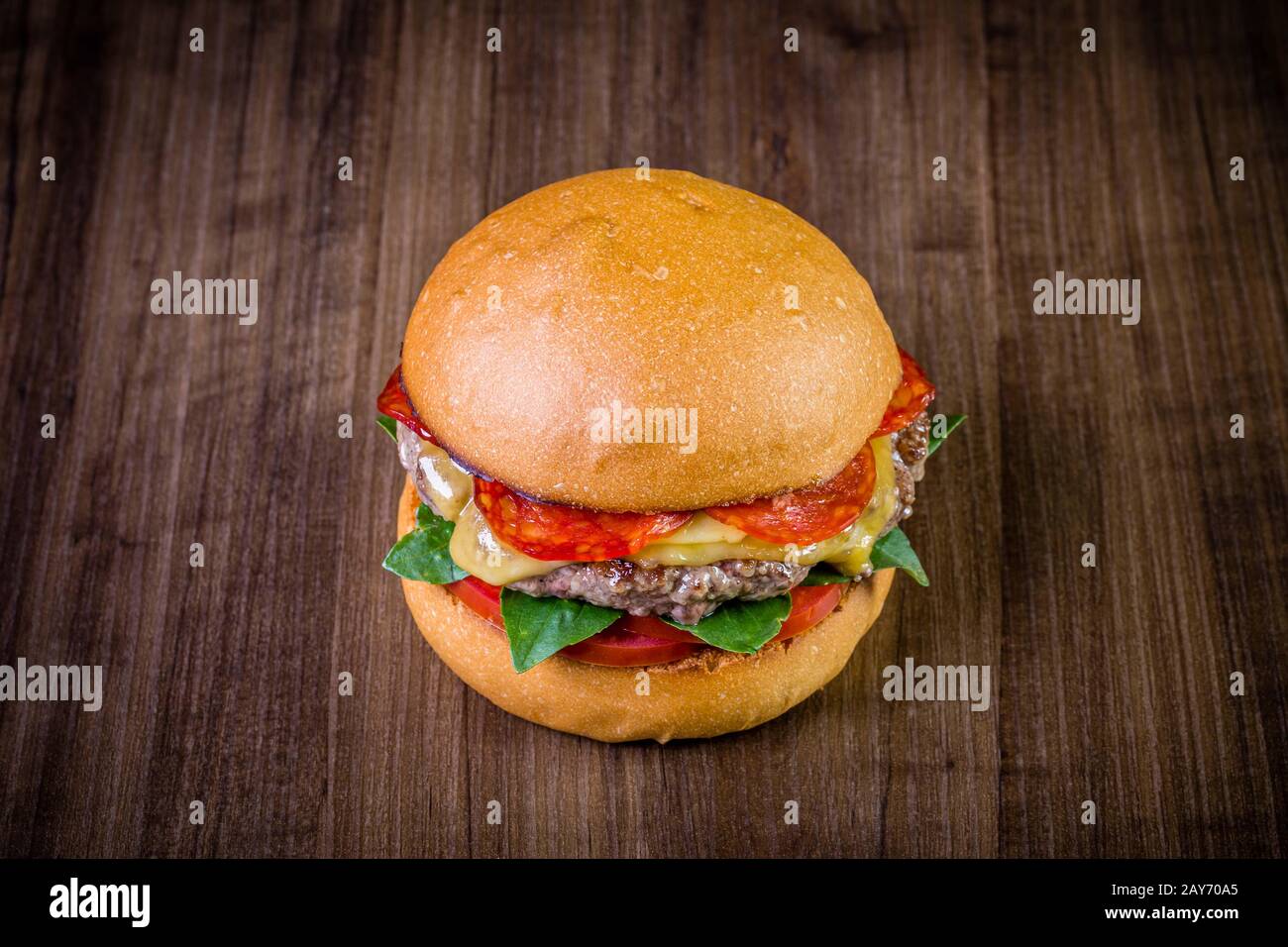 Craft beef burger with cheese, italian peperoni, tomato and basil leafs ...