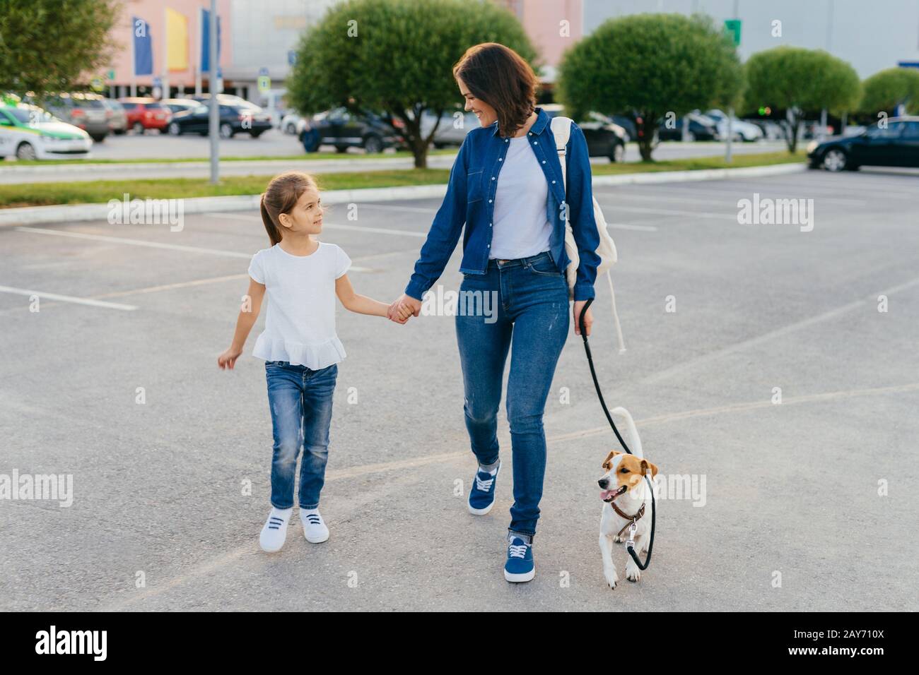 Photo of happy daughter and mother have outdoor stroll against city ...