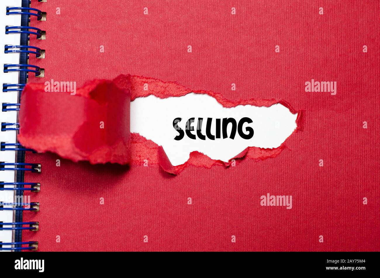 The word selling appearing behind torn paper Stock Photo - Alamy