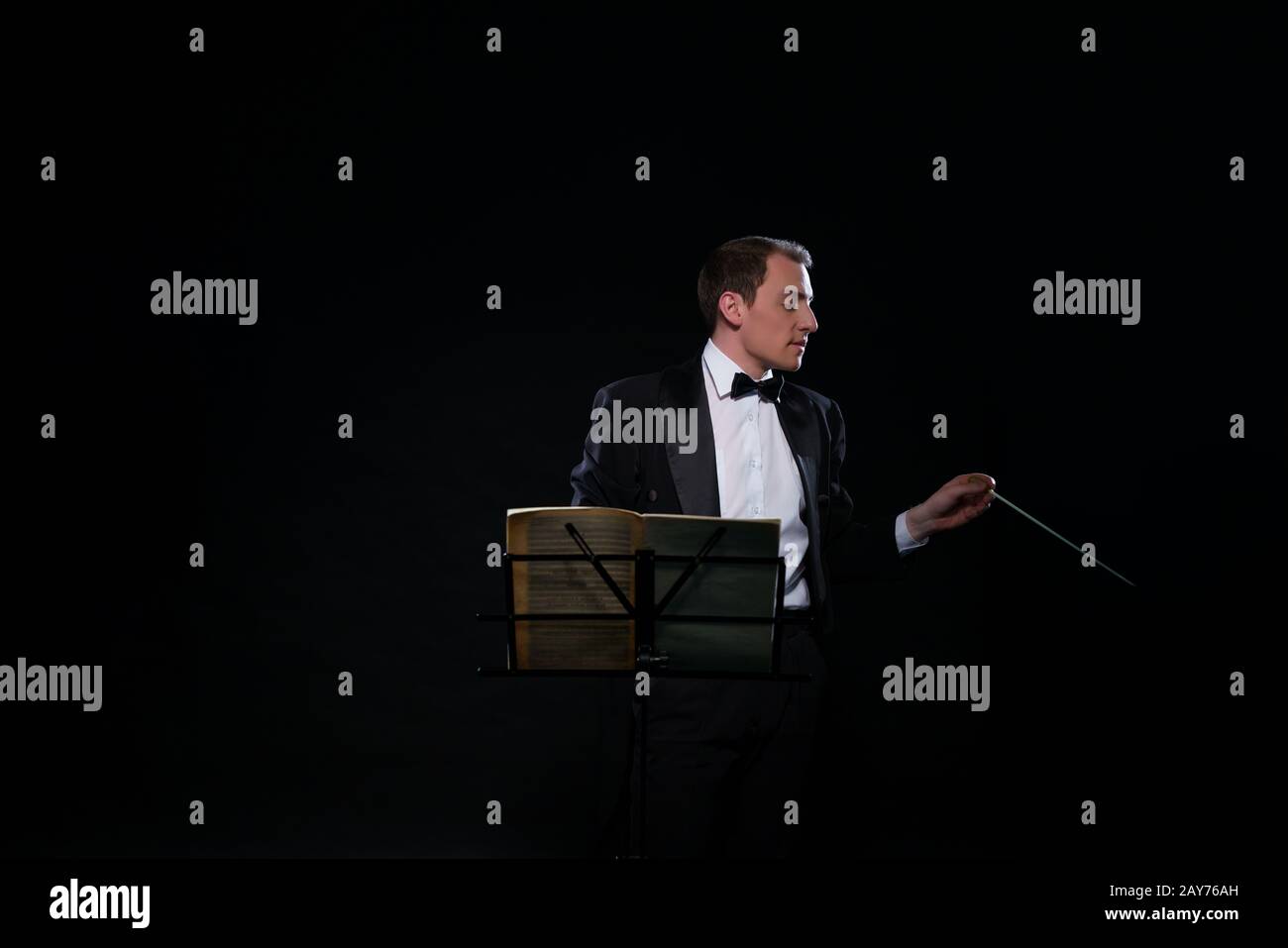 Orchestra conductor in black tuxedo in dark studio Stock Photo - Alamy